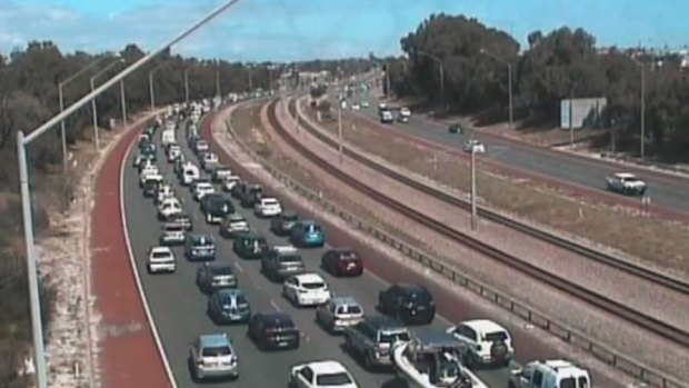 Perth freeway gridlocked after car rolls onto roof
