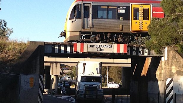 Truck stuck beneath bridge