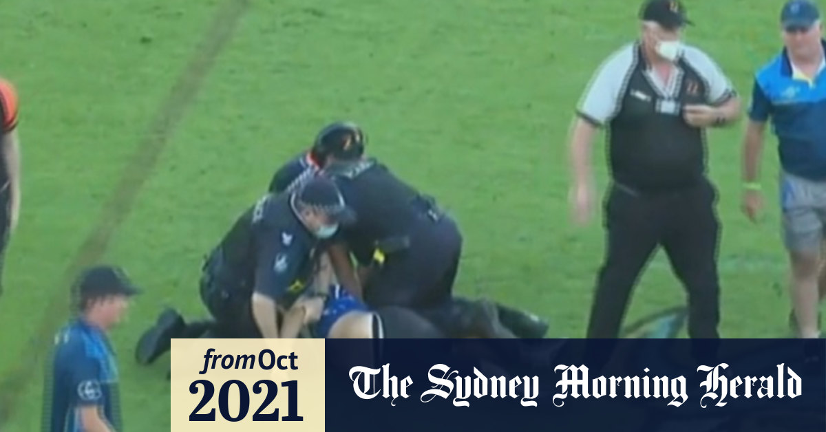 Video: Police escort football fan off field after he allegedly punched ...