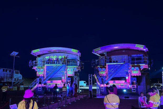 Gina Rinehart handholds Peter Dutton at neon bush doof