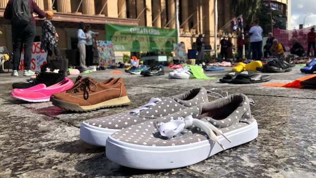 Hundreds of children's shoes laid out in silent Brisbane climate protest