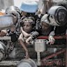 Palestinians wait to collect free food from a charity kitchen in Gaza City.