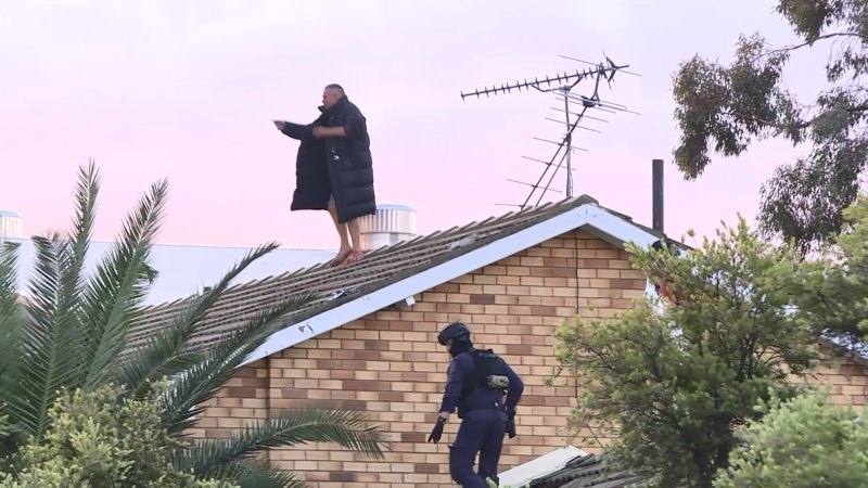 Man dies and relative in custody after rooftop standoff with police in ...