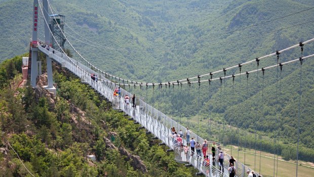 Glass bridge in China breaks, trapping tourist 100m above ground