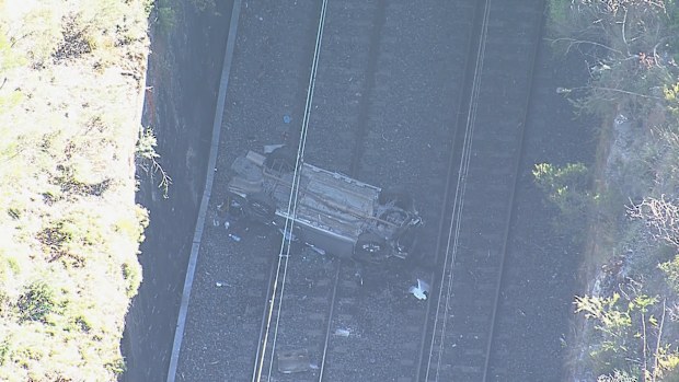 Car crashes upside down onto train tracks west of Sydney | Nine.com.au