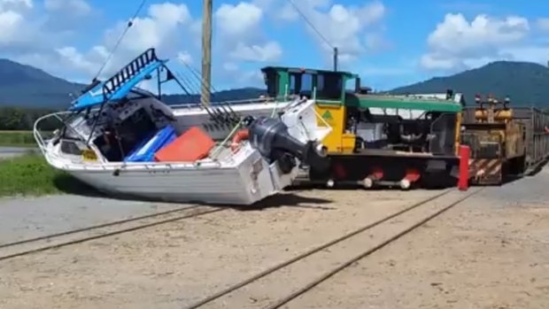 Cane train derails after hitting fishing boat on tracks in Cairns