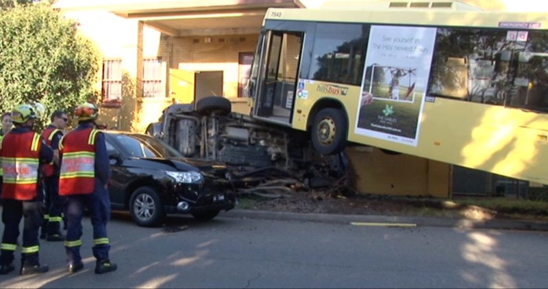 Car left wedged under a bus after crash at Northmead