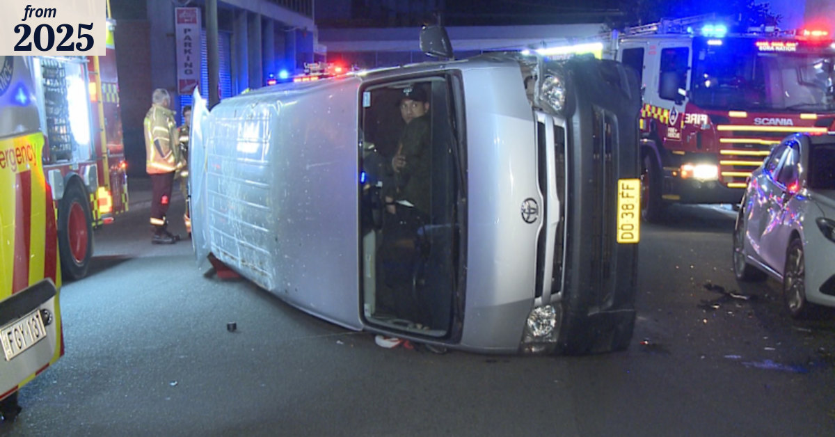 Driver charged after being trapped in flipped van